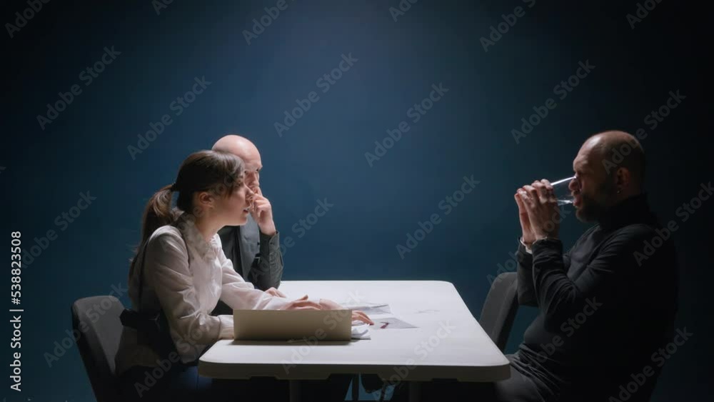 Lawyer enters room and sits down next to client. Police officers ...