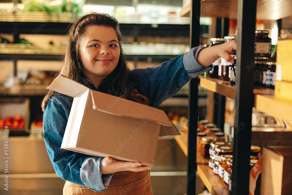 Convenience store employee with Down syndrome restocking food products ...
