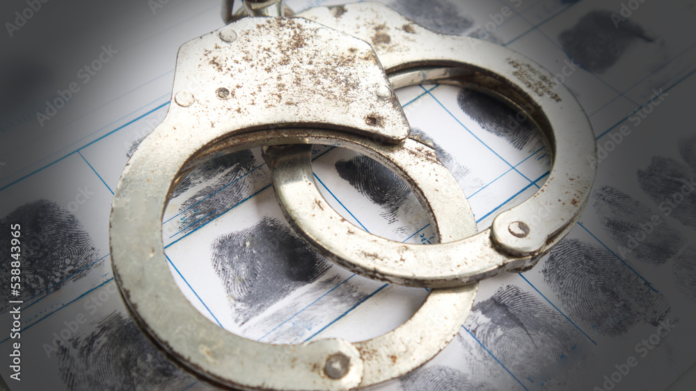 Crime and violence concept.Police Handcuffs on fingerprints crime page ...