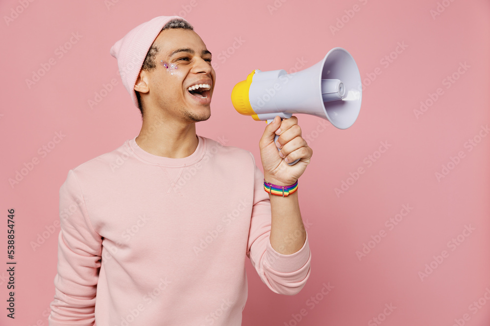 Side view expressive happy young gay man wear sweatshirt hat hold ...