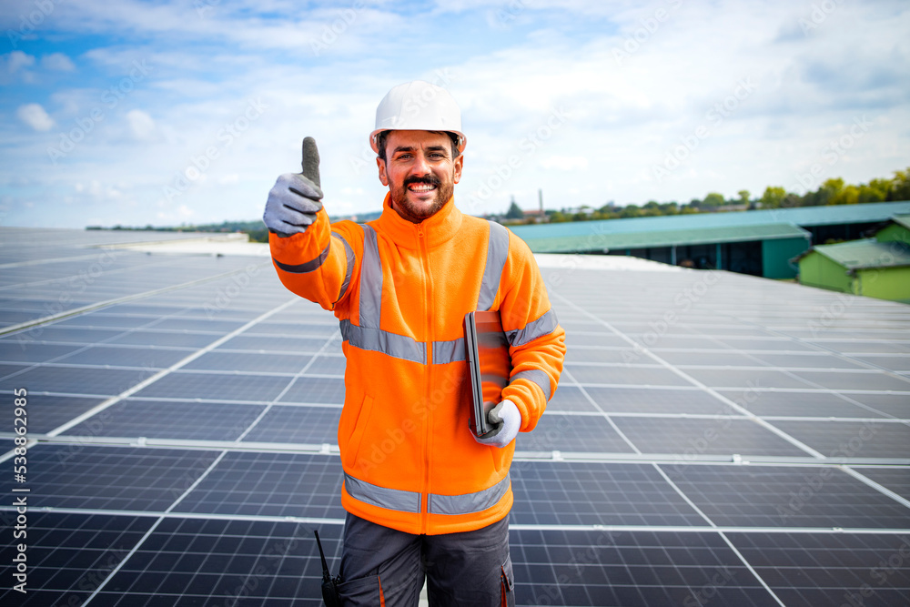 Foto de Portrait of professional solar company worker holding thumbs up ...