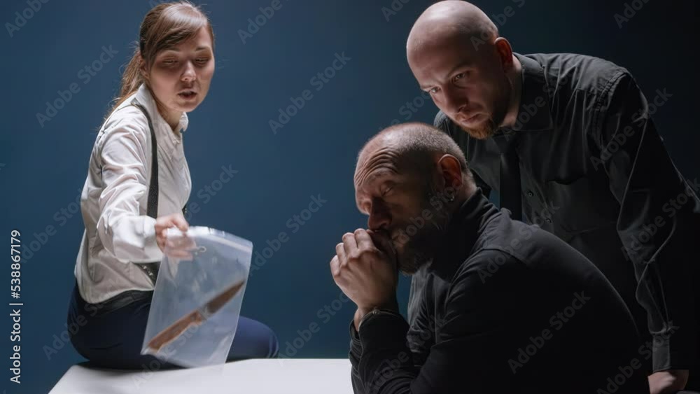 Police interrogation without lawyer. Detective cop shows knife in blood ...