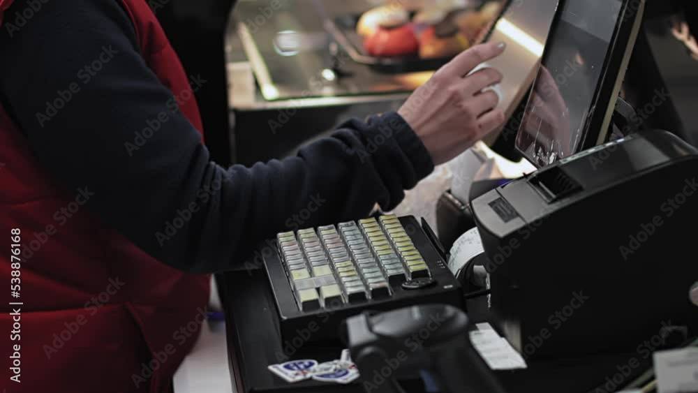 Female cashier tears receipt from cash register. Shopping at mall and ...