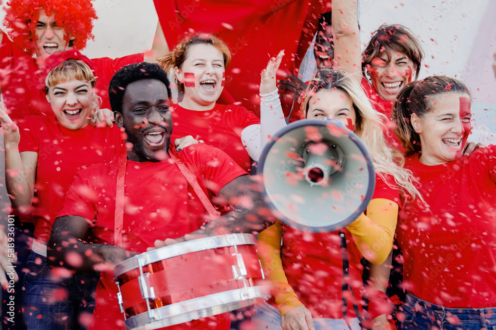 Multiracial red sport football fans celebrating throwing confetti with ...