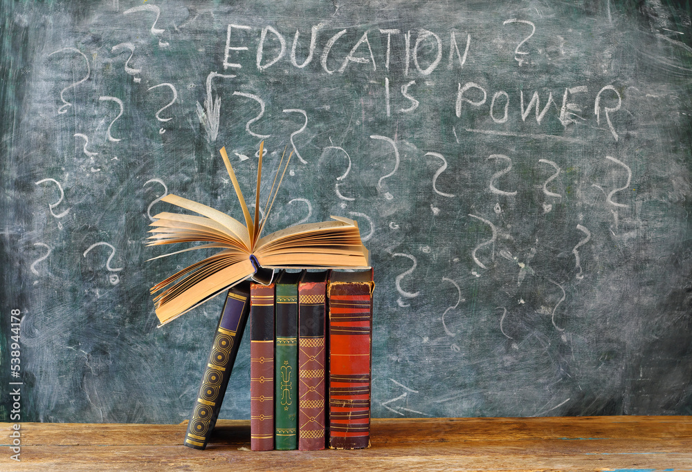 Open book and row of hardback books with education is power slogan and ...