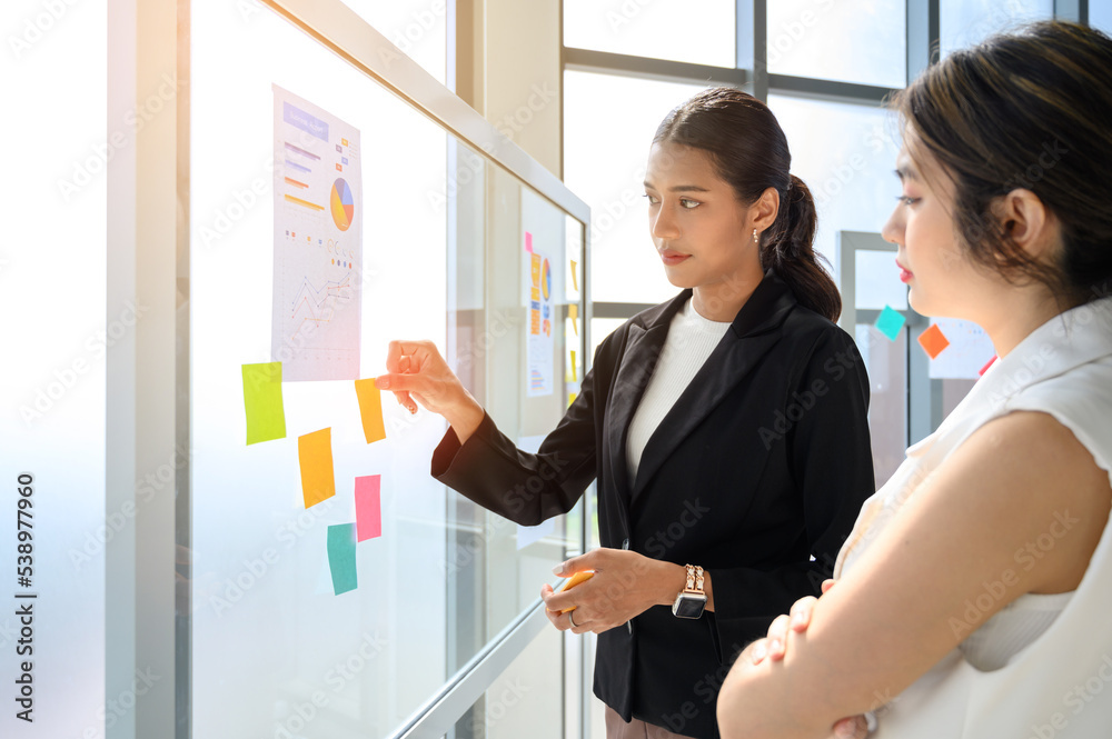 young modern businesswoman in smart casual using sticky notes for ...