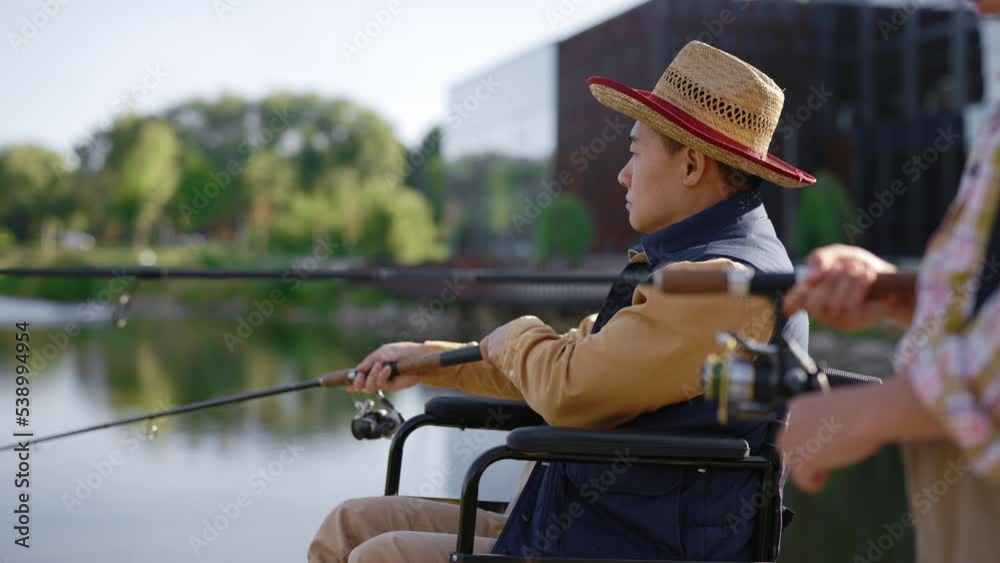 Close view of the disable dad fishing with his son on the early morning ...