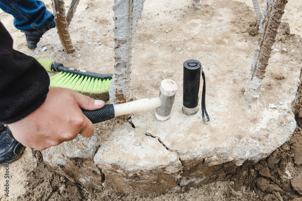 Construction works. Seismic test on concrete pile. Engineer using the ...