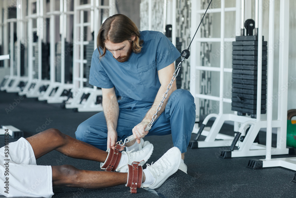 Doctor wearing sport equipment for stretching exercises to patient ...