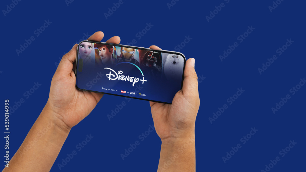 Boy holding a smartphone iPhone 14 Pro with Disney+ (Disney Plus ...