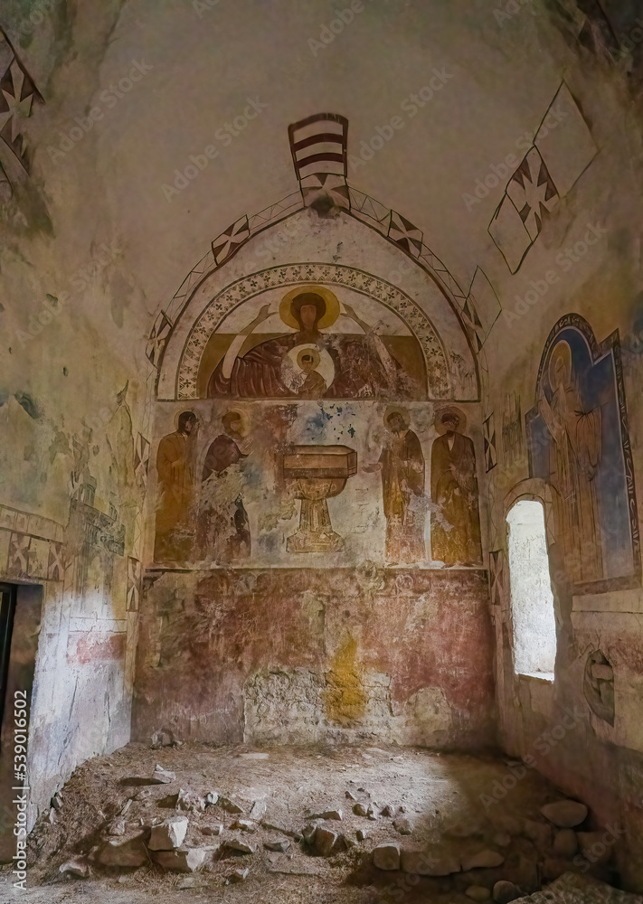 murals and wall paintings inside an old partly ruined church in a ...