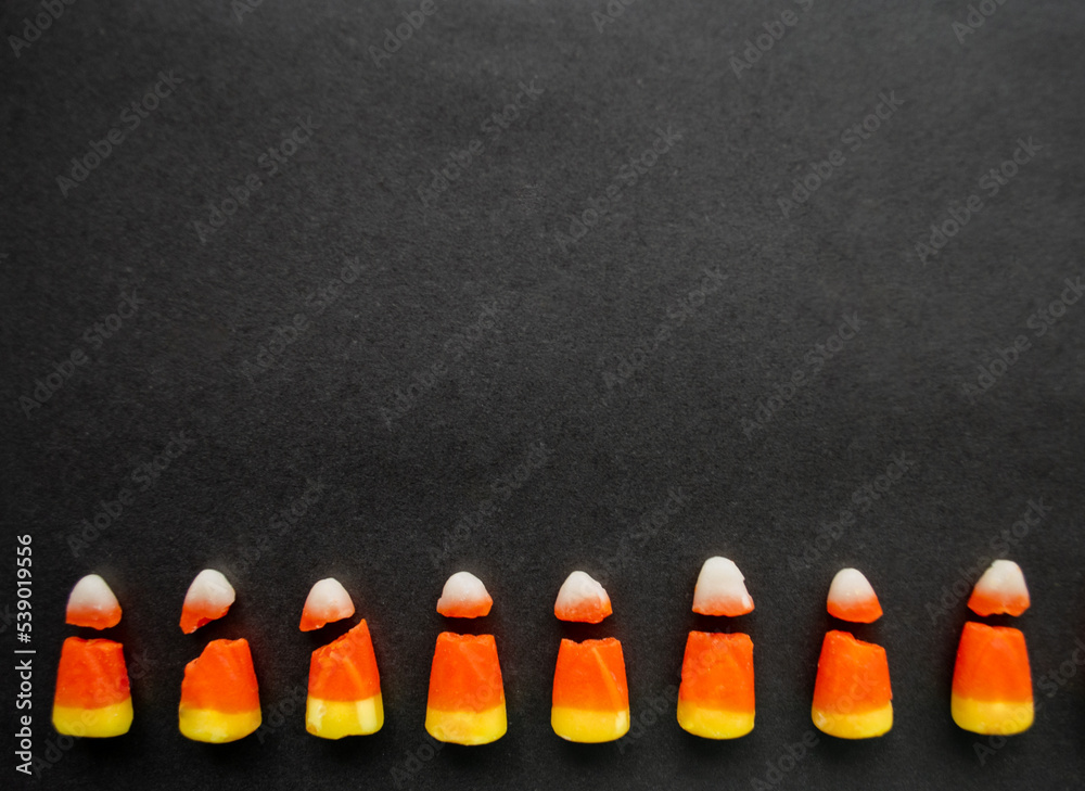 Broken candy corn look like small bad teeth. Black background. Copy ...