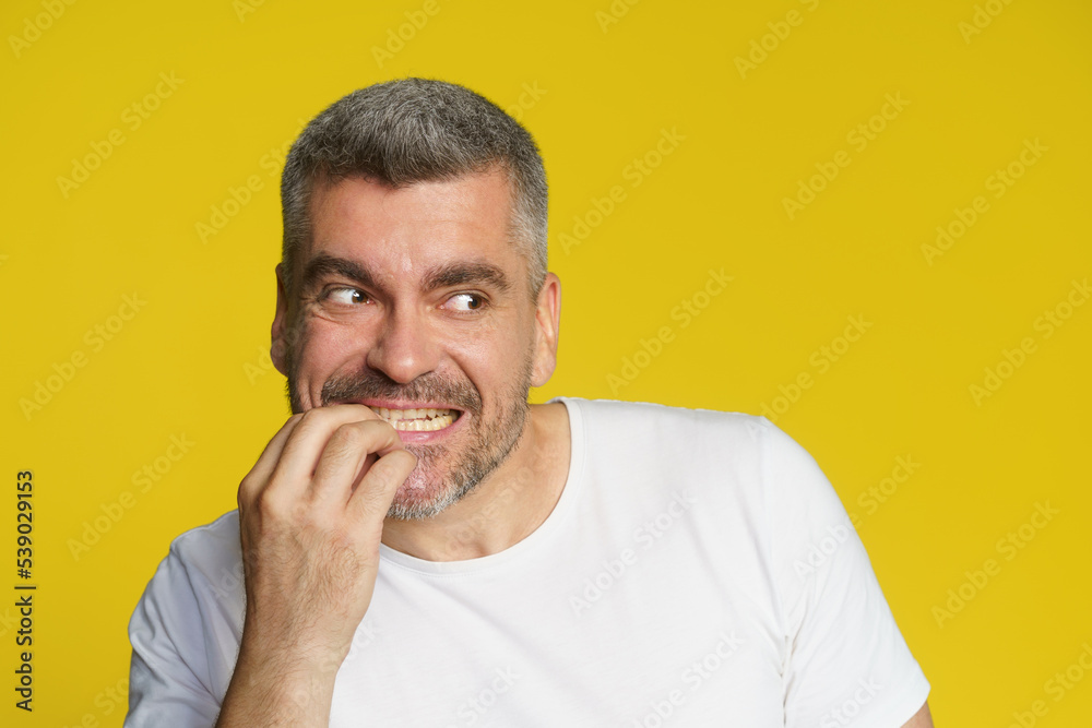Scared of competitor handsome middle aged man bitting his fingernails ...
