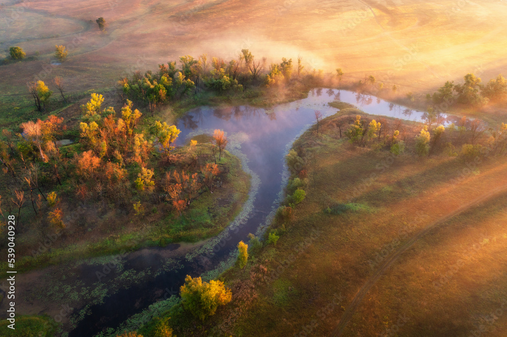 Aerial view of beautiful curving river in fog at sunrise in autumn in ...