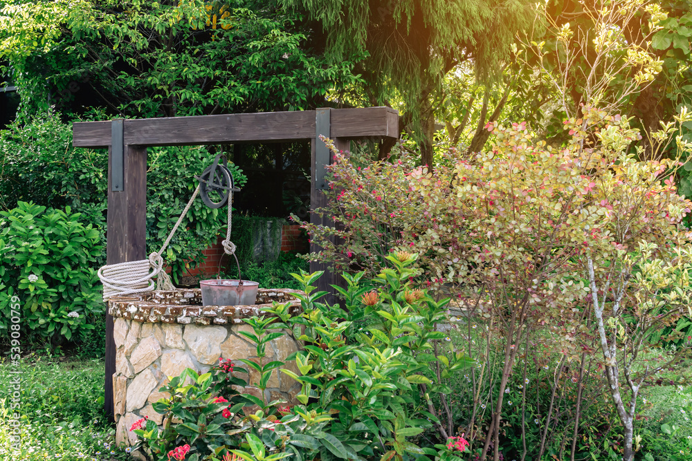 Beautiful artesian well made by stones and wheel pulley with metal ...