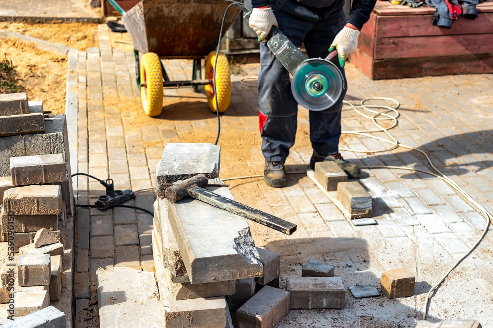 A construction worker using an electric grinder and a diamond cutting ...