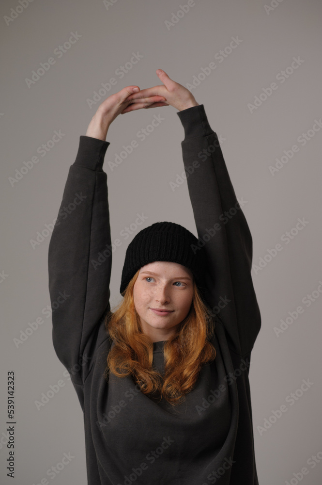 young girl model in black cap and grey jackett isolated on grey ...