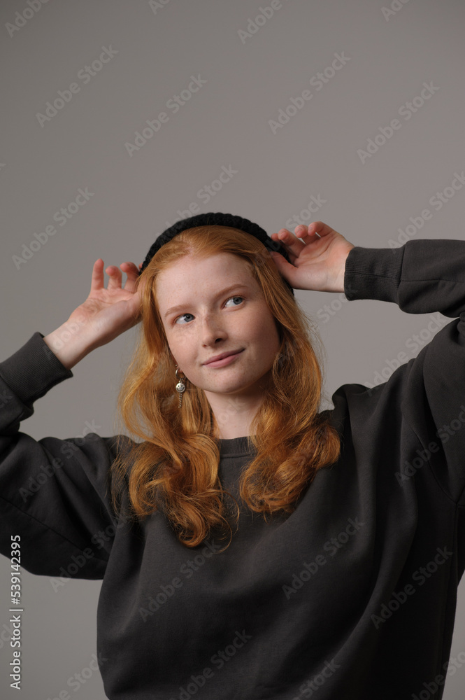 young girl model in black cap and grey jackett isolated on grey ...