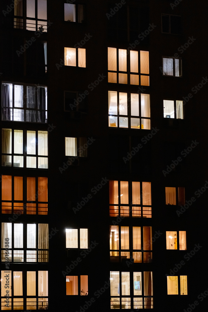 Illuminated windows of night multistory apartment building. Lighted ...