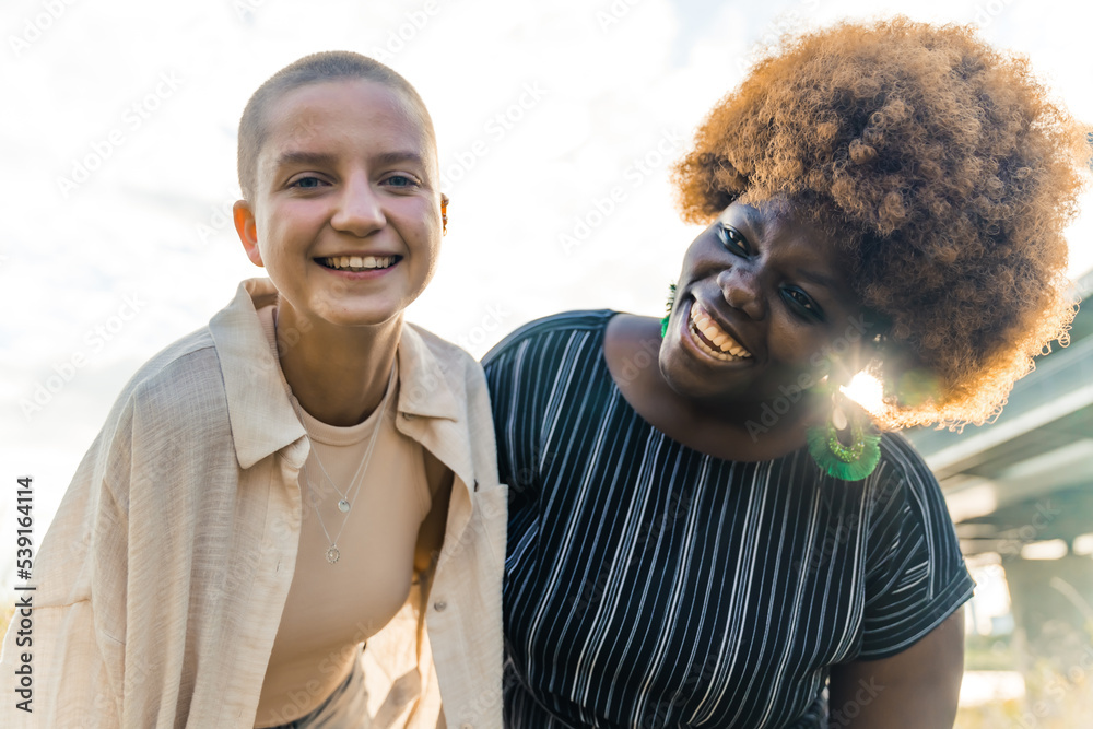 Two different woman showing off their friendship. Outdoor closeup ...