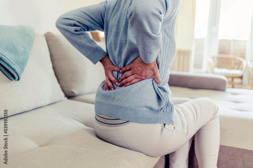 Cropped image of senior woman suffering from backache in morning ...