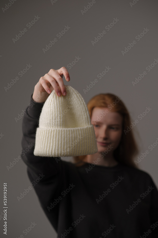young girl model in white cap and grey jackett isolated on grey ...