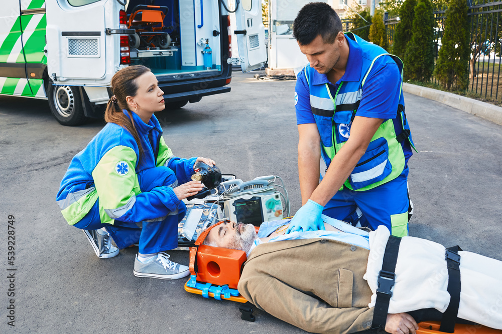 EMS, first aid. Two paramedics performing closed-chest cardiac massage ...