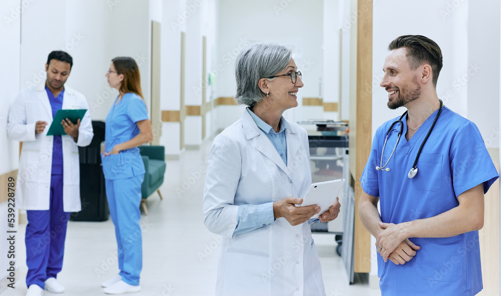 Healthcare doctors making rounds, talking in hospital corridor while ...