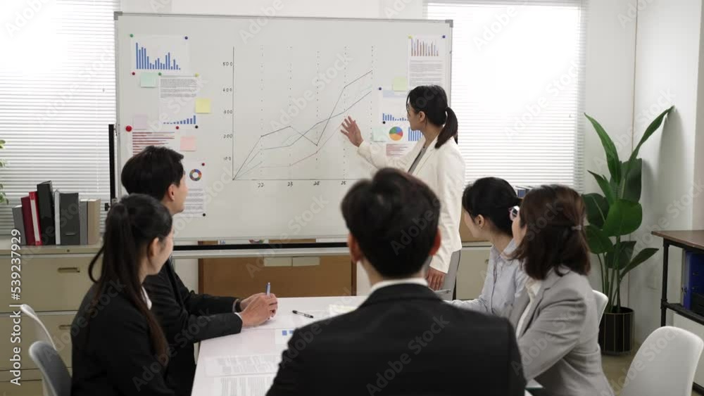smiling asian woman team leader analyzing graph on whiteboard and ...