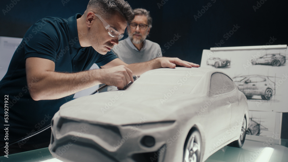Automotive engineer works on the sculpture of a prototype car model ...