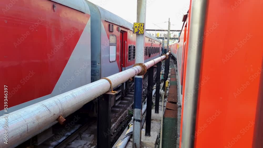 two passenger train standing at railway station platform with water ...