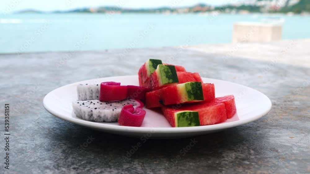 Rotating shot of watermelon slices and gragon fruits served on a white ...