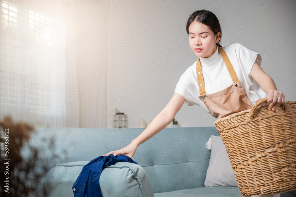 Beautiful young housekeeper maid doing housework holds basket wood of ...