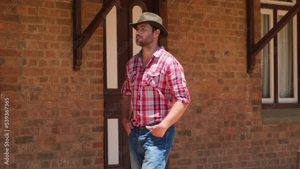Real working cowboy riding in sunset light. male cowboy in a plaid ...