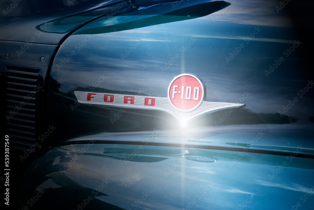 Ford F-100 emblem and lettering on the blue-green paint of a classic ...