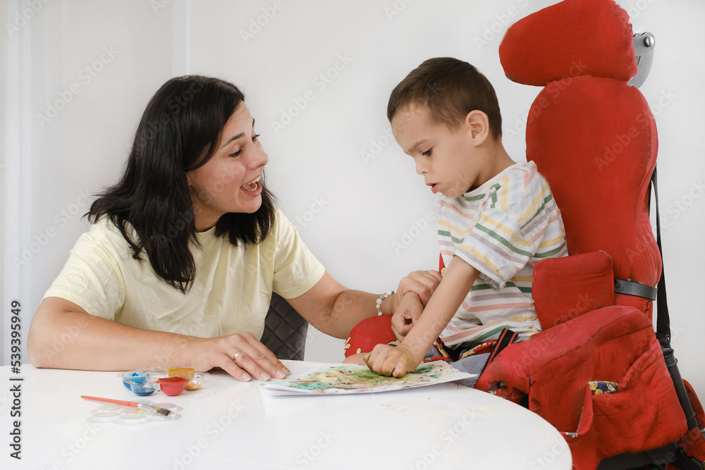 Child with cerebral palsy painting with fingers and hands boy that has ...