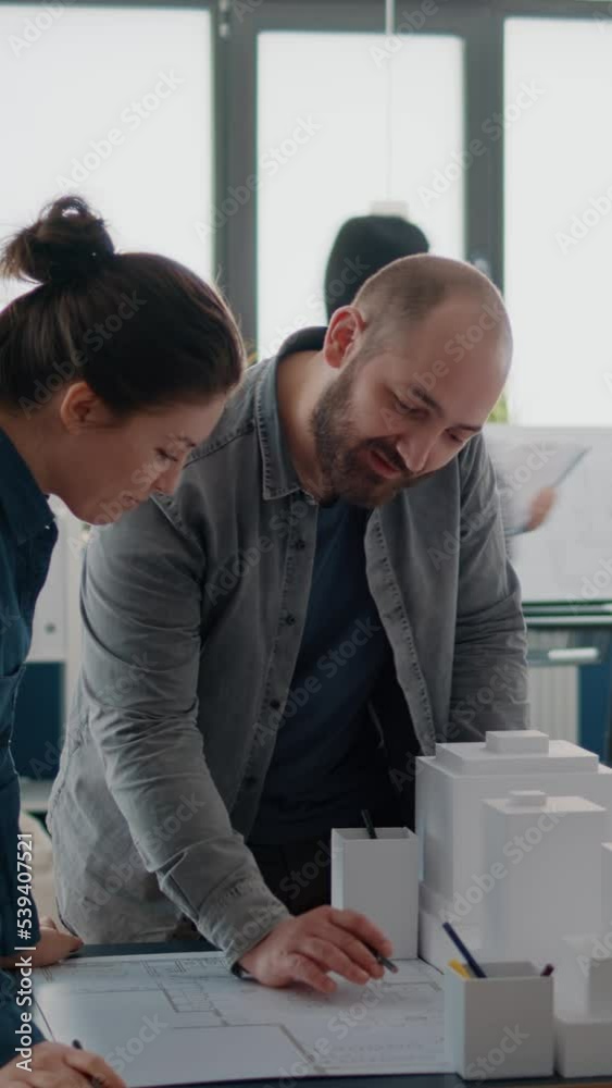 Vertical video: Team of colleagues using building model for inspiration ...