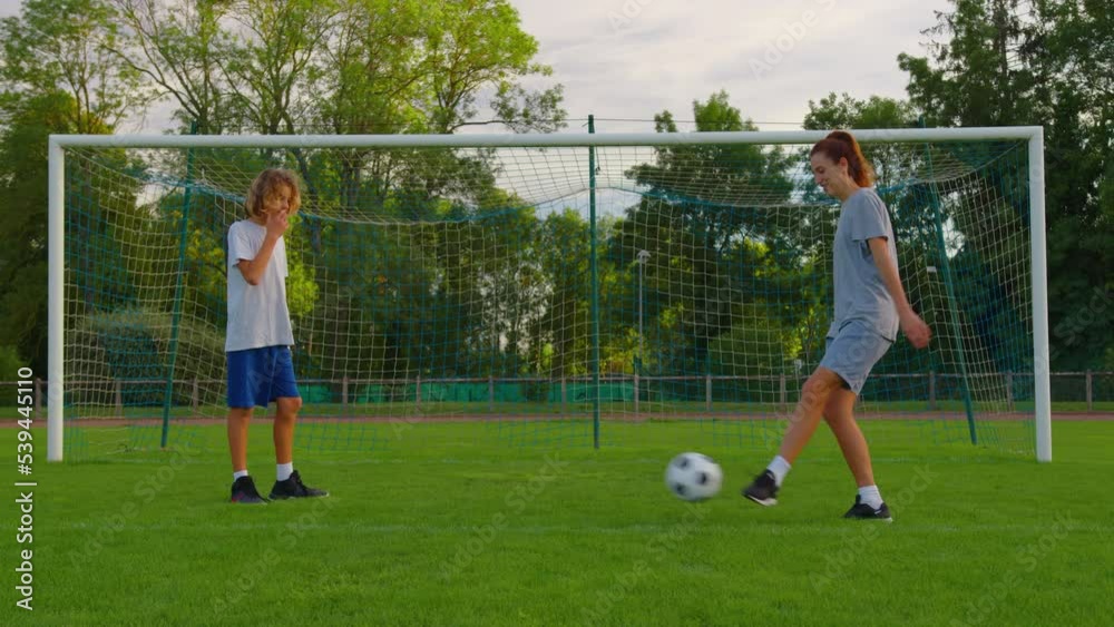 Mother, son playing soccer for fun outdoors in park. Happy family ...