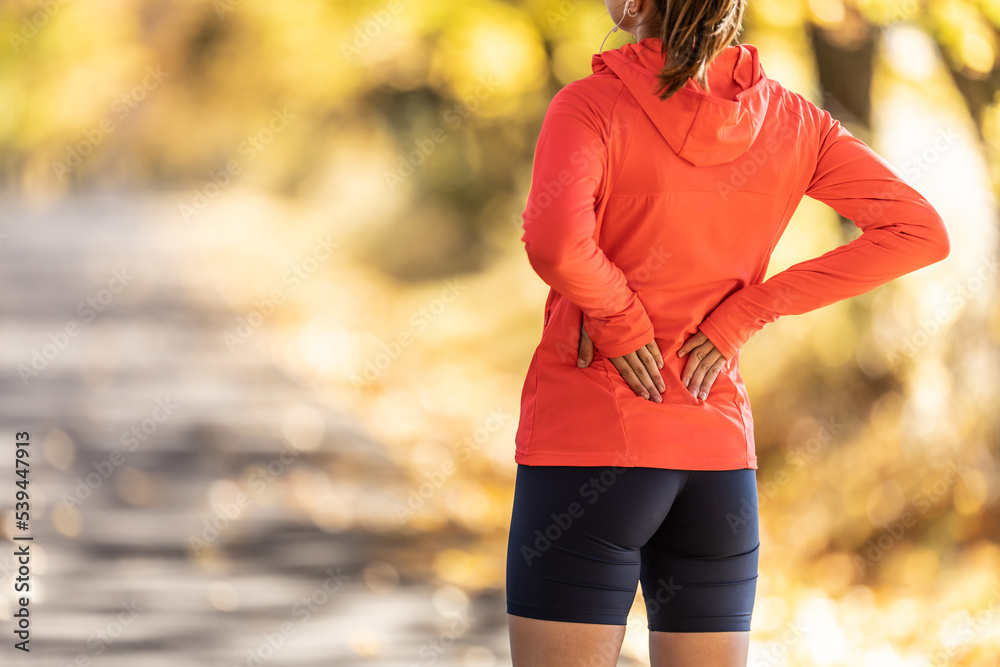 Young woman with an athletic figure and a lower back injury. Back pain ...