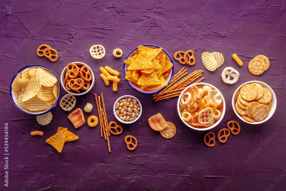 Salty snacks. Party food mix background. Potato and tortilla chips ...