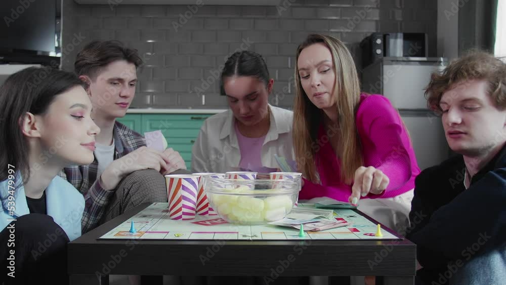 A group of friends playing a board game with cards and dice. Stock ...