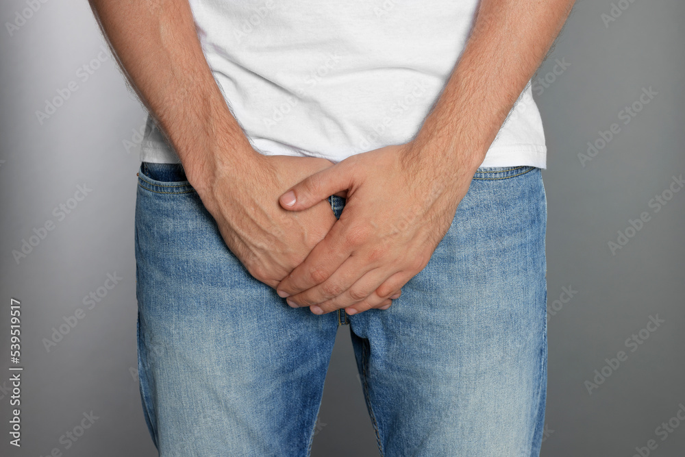 Man suffering from genital herpes on grey background, closeup Stock ...