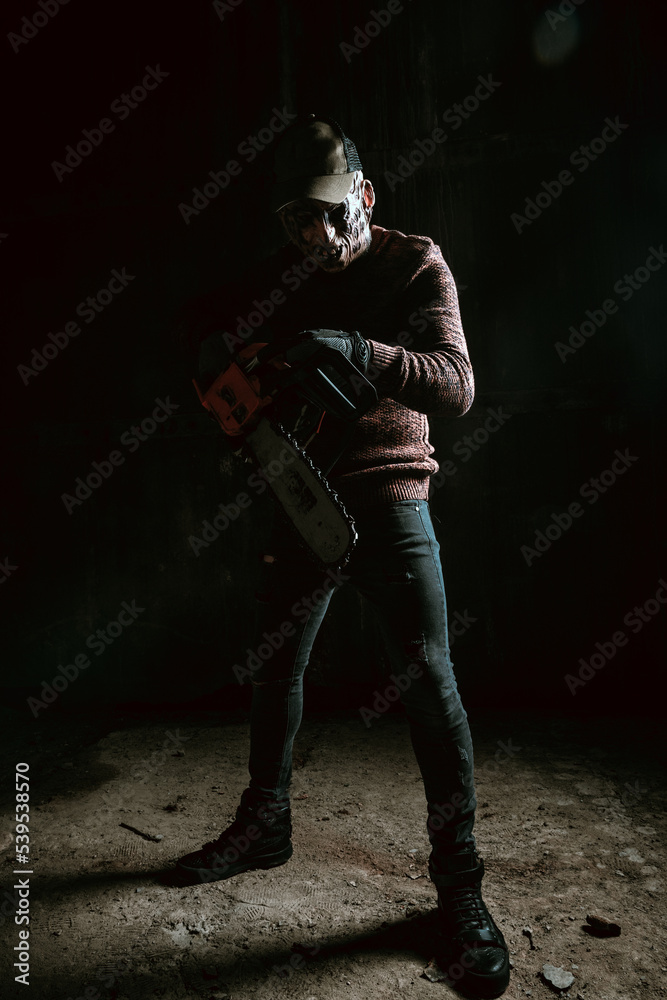 Evil in mask with chainsaw, horror Halloween scene in dark room Stock ...