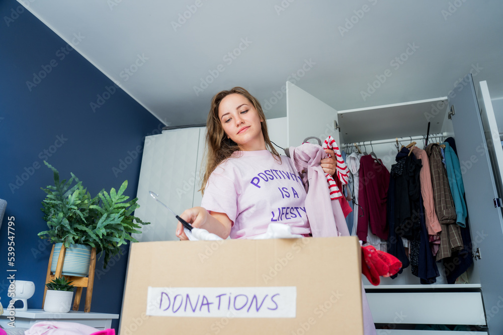 Woman putting selected clothes from her wardrobe for donating to a ...