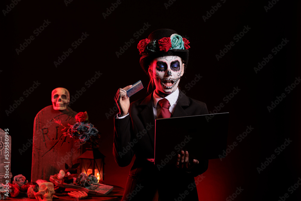 Creepy person doing online shopping with skull make up, using credit ...