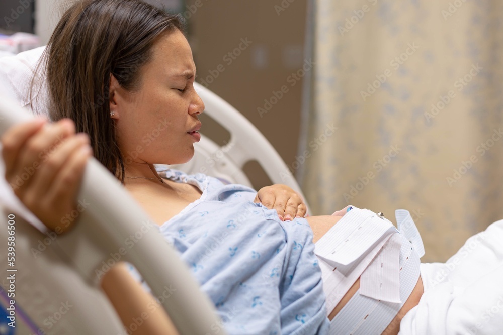 A pregnant woman lying in the hospital bed being monitored before ...