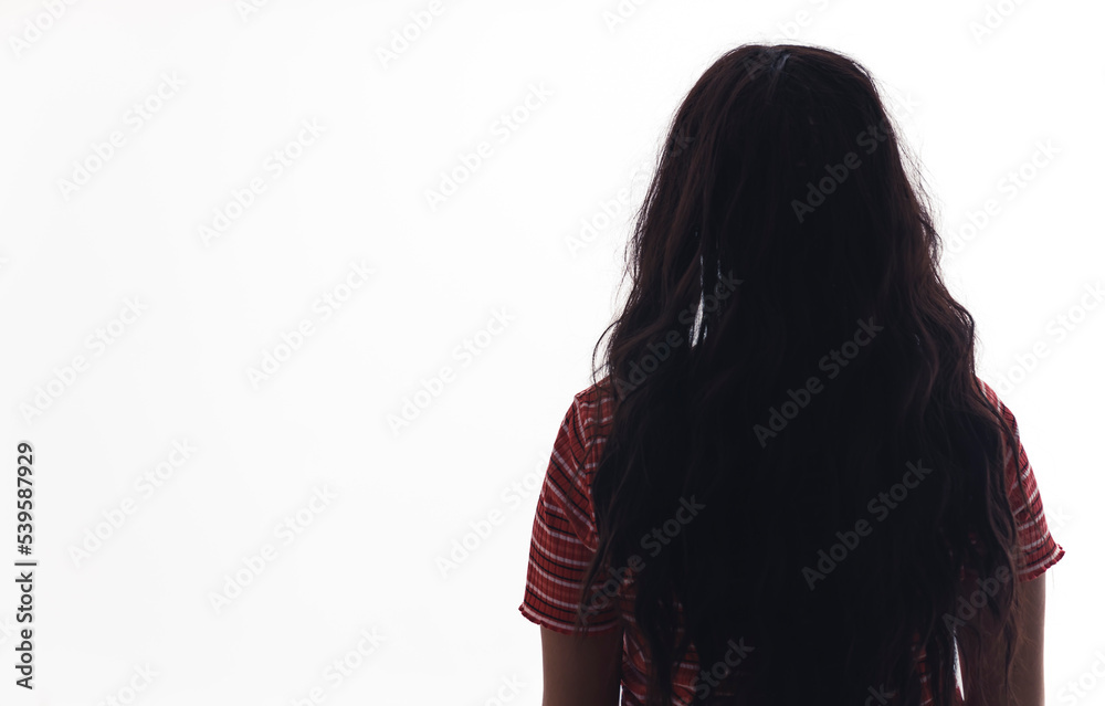 Rear view of unrecognisable young woman with long dark hair back turned ...