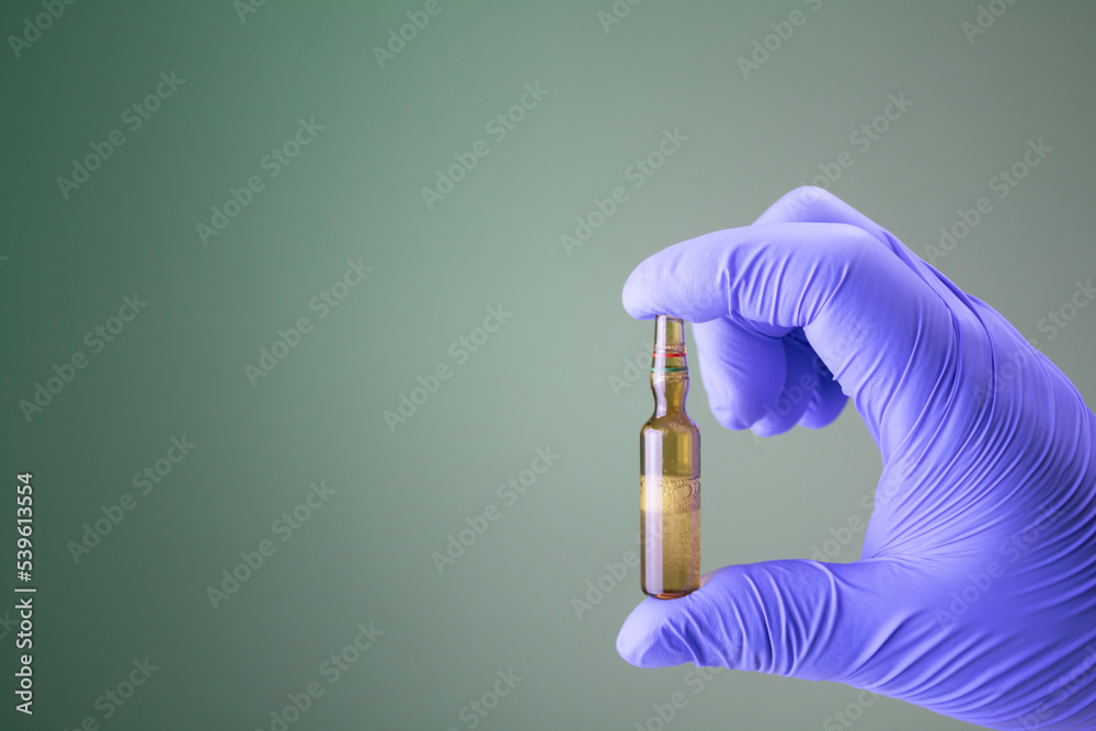 Hand holding an anesthetic container isolated, green background ...