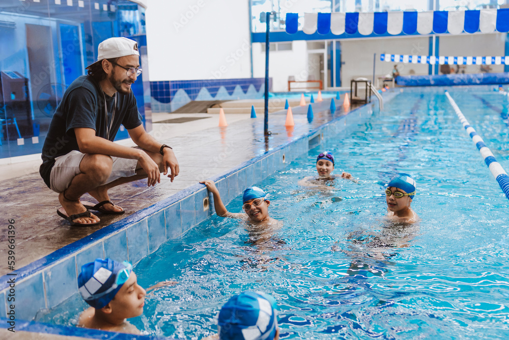 Latin swimming man trainer with chronometer talking some advices to ...