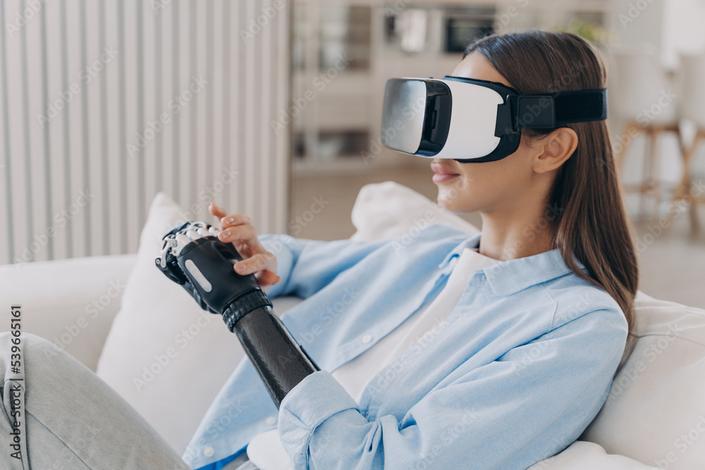 Disabled girl in VR glasses interacts with augmented reality, touches ...